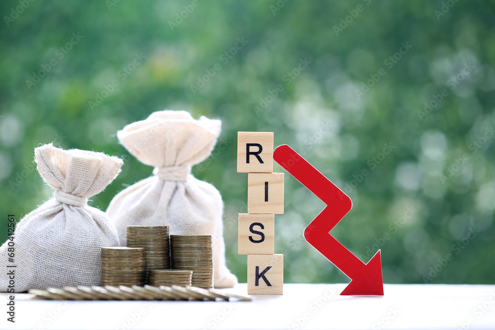 Risk word with red arrow graph and money bag on natural green ...