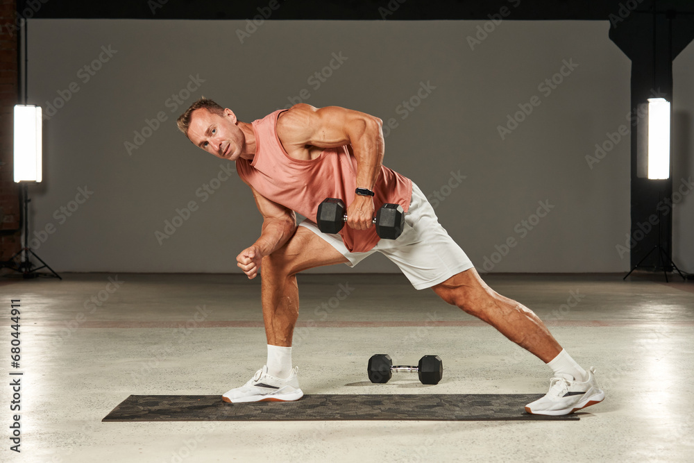 one-arm dumbbell row in a bent-over position with emphasis on the leg ...