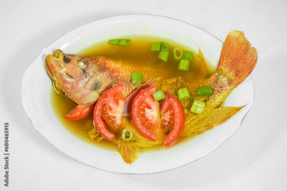 Tilapia fish soup in a bowl with turmeric sauce and spices, using ...