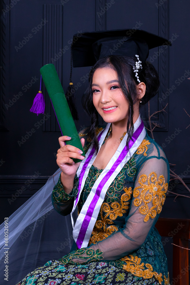 beautiful Asian girl who graduated sitting on a chair smiling faintly ...