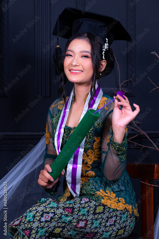 beautiful Asian woman graduating sitting on a chair smiling sweetly ...