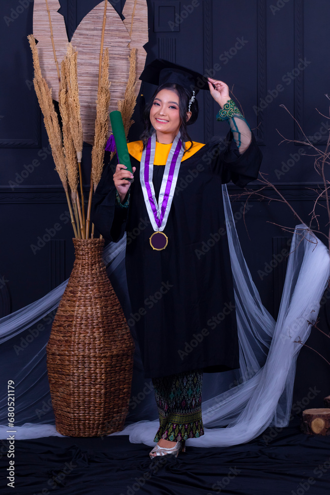 beautiful Asian girl graduating, smiling happily, holding a diploma and ...