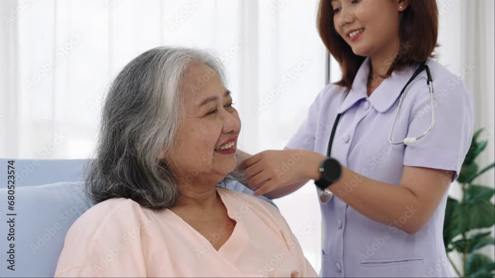 Close-up A nurse combs the hair of an elderly Asian patient and offers ...