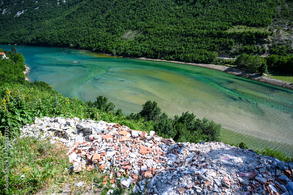 Construction waste dumped next to a beautiful green river. Destruction ...