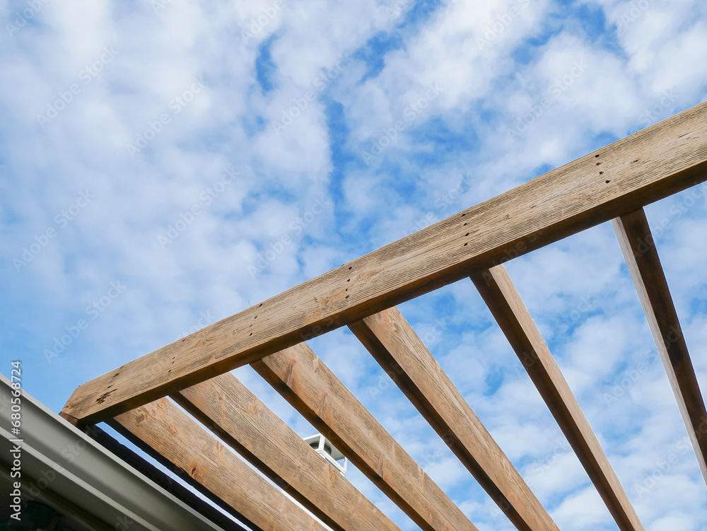 Pergola attached to house near roof gutter, sanded rafter ready for re ...