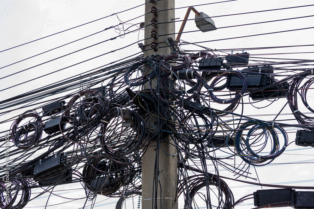 Intertwined electric wires. A tangled electrical wires showcasing the ...
