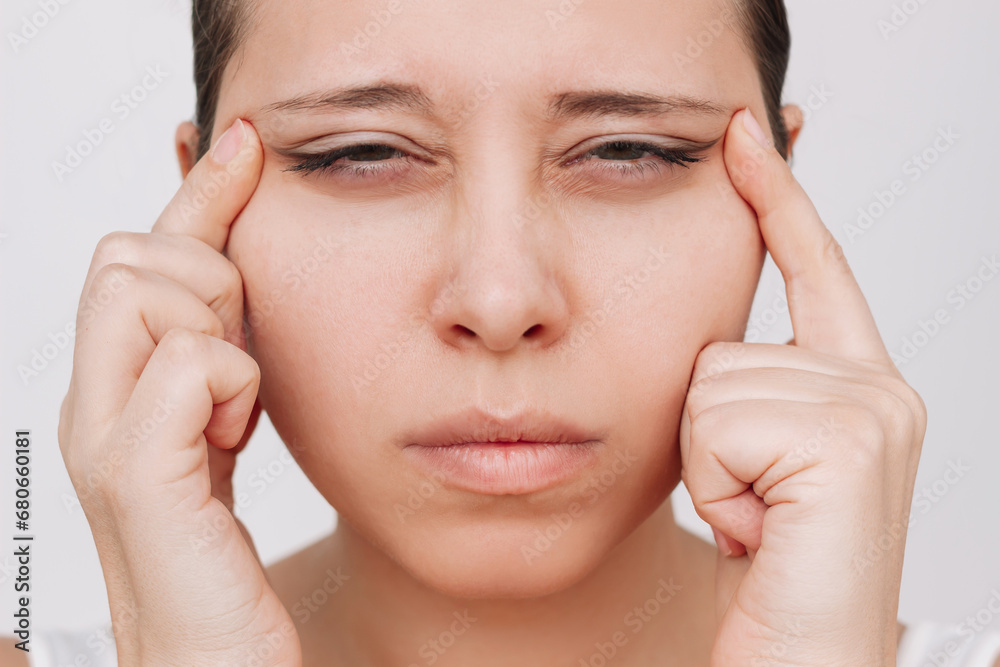 Young caucasian woman with poor eyesight squints pulling eyelids to the ...