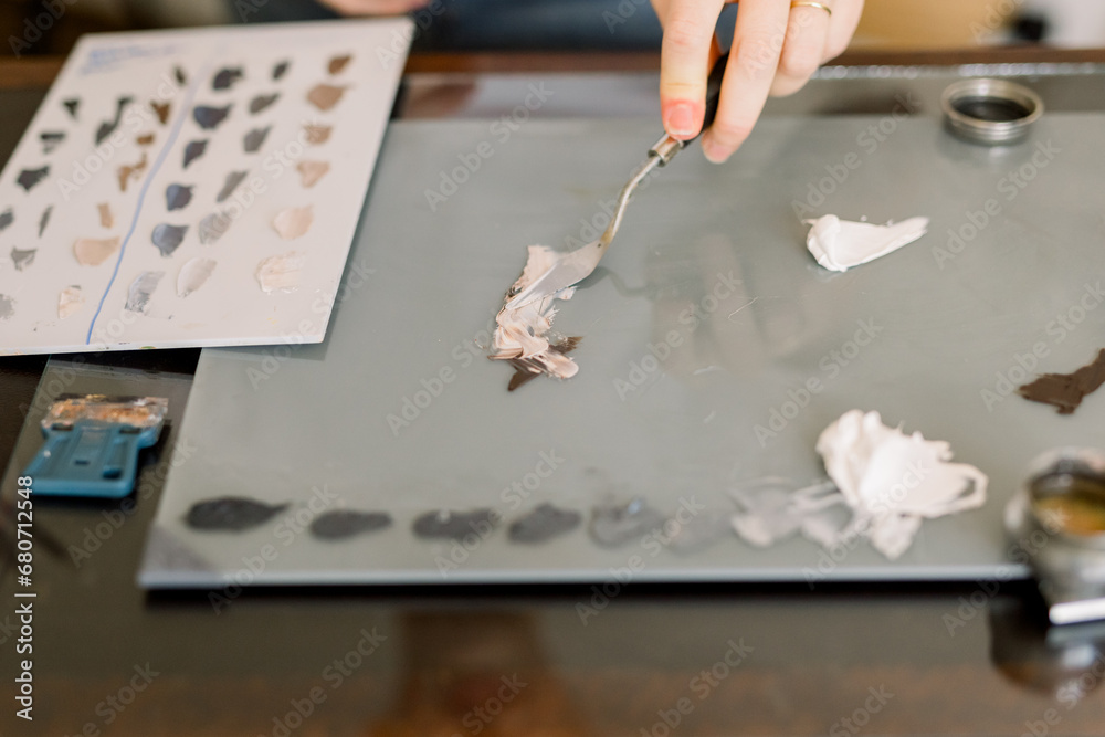 An artist is smearing acrylic paint on her metal mixing tray and ...