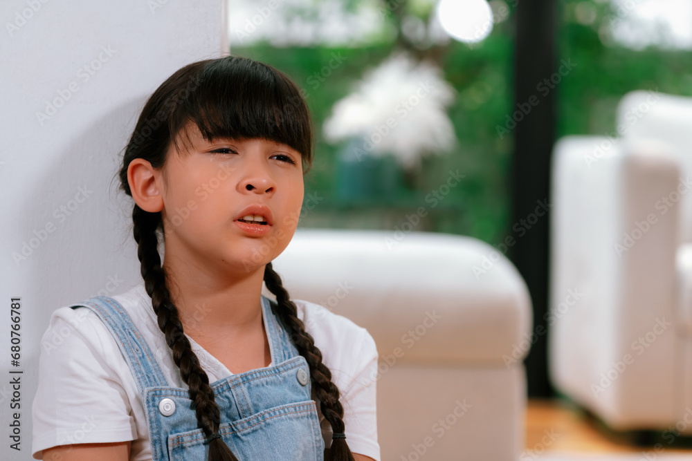 Sad little girl sitting alone in living room crying, feeling lonely ...