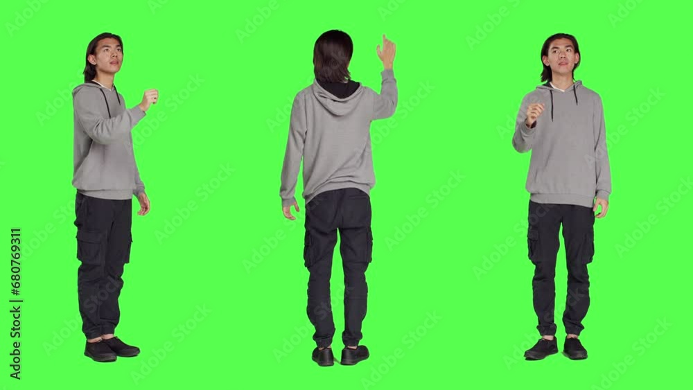 Male model looks at hologram icon on camera with full body greenscreen ...