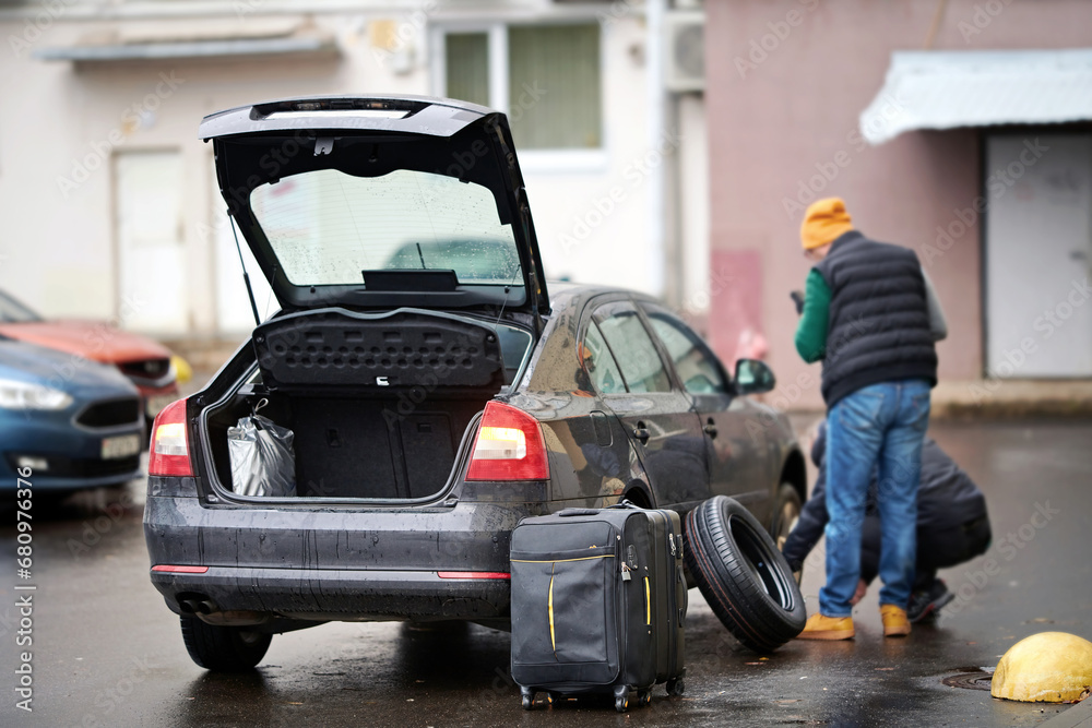 Man replacing flat tire on taxi car. Driver replace tire after puncture ...