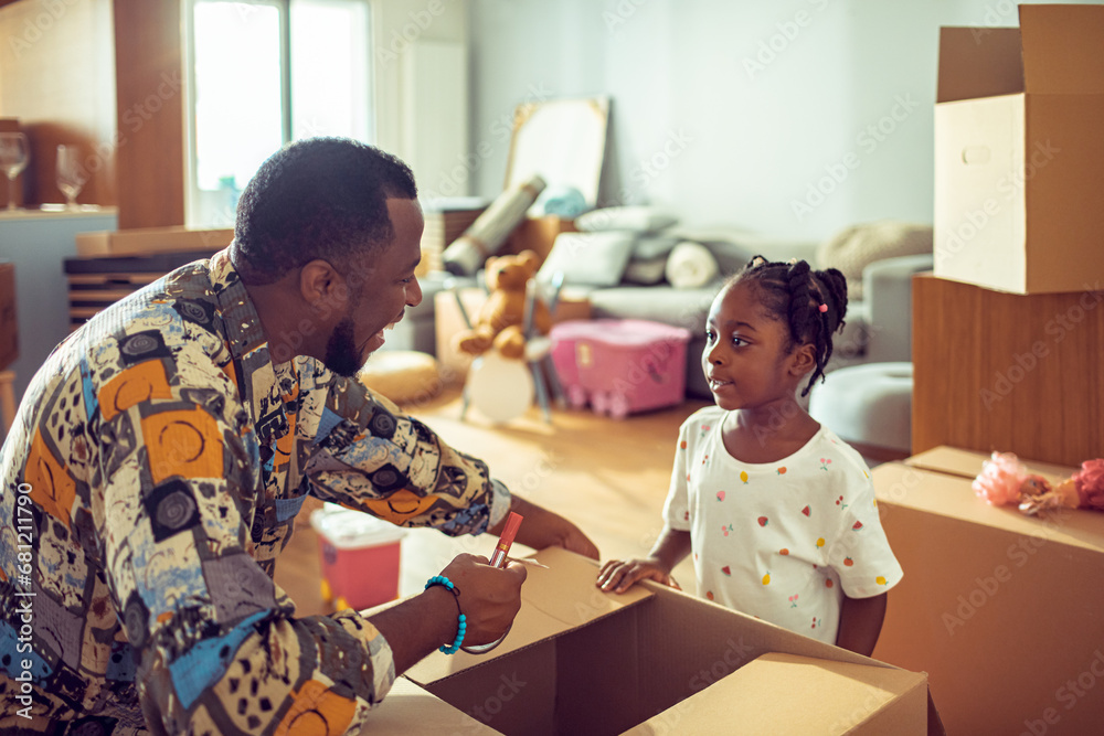 Father packing valuables in box during moving day with daughter Stock ...