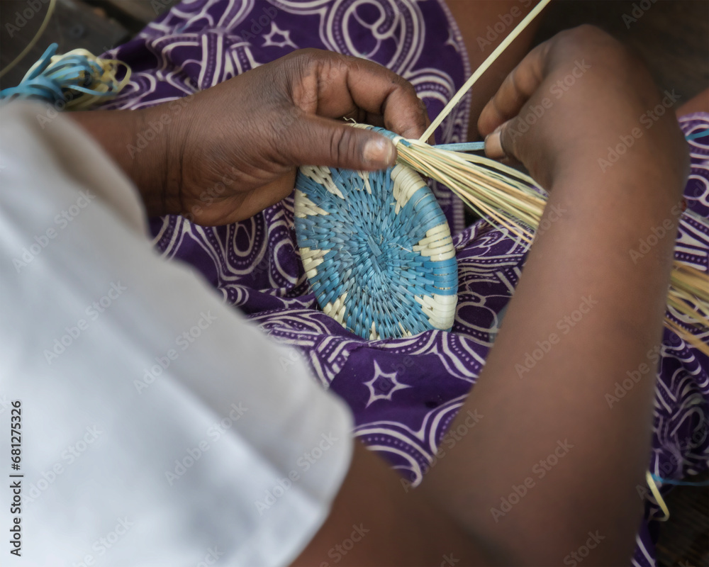 African woman hand making, weaving a basket with a pretty pattern ...