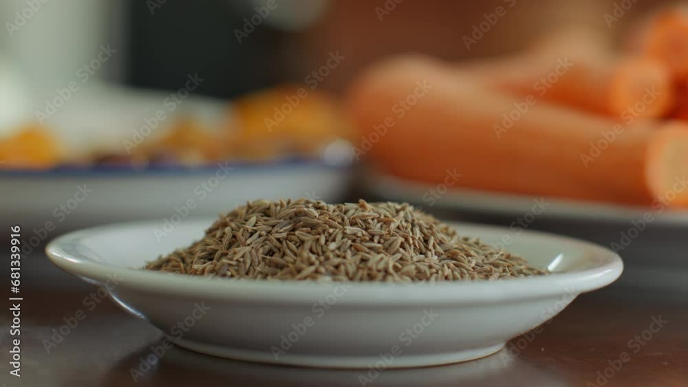 Seasoning for cooking brown cumin is in a white saucer. The plate is ...
