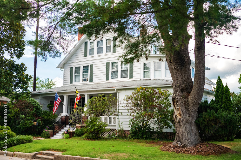 classic American house colonial style. Veranda with columns and flag at ...