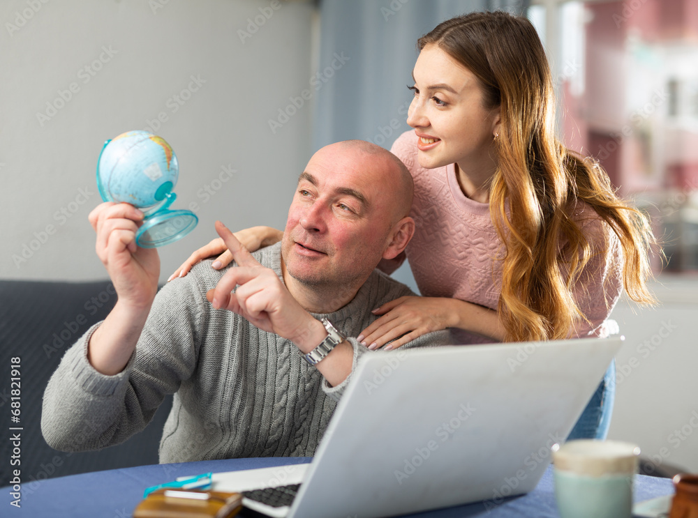 Man holding globe and choosing travel destination with his wife. Stock ...