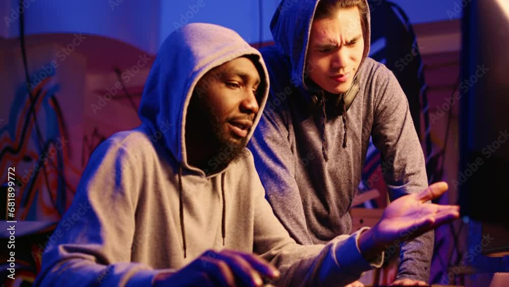 Hacker Talking To Asian Colleague In Rundown Hiding Place Brainstorming Ways To Find Exploits