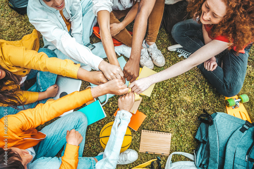 Multicultural university students stacking hands together in college ...