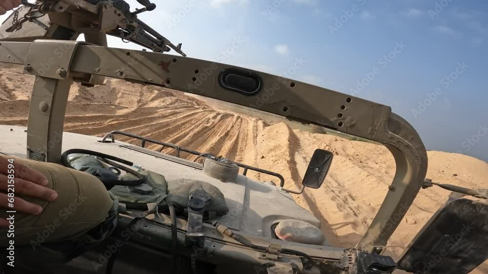 IDF soldier holds mounted machine gun at ready as Humvee patrols the ...