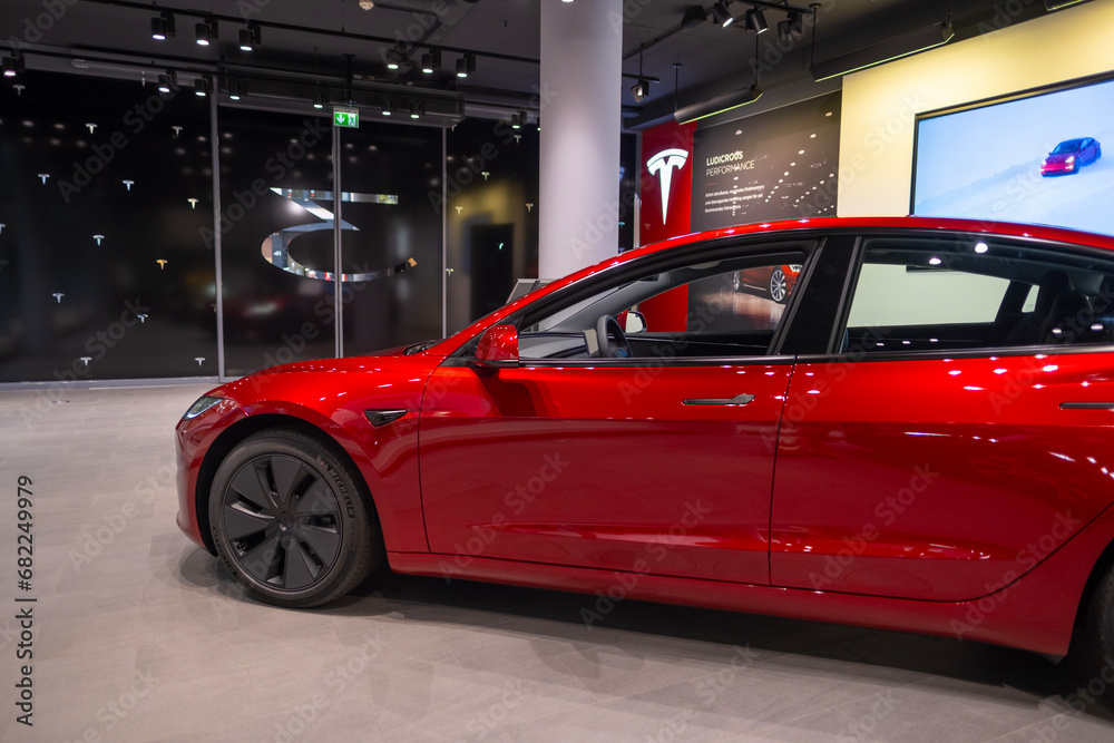 new red Tesla Model 3 electric car in showroom, trends in use EV in ...