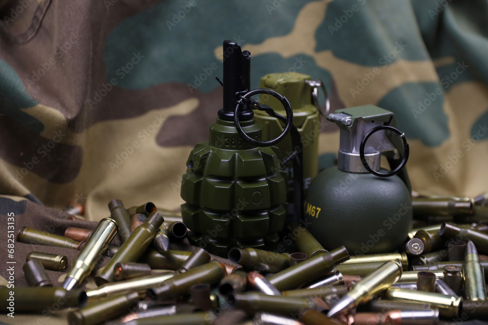 Different types of ammunition and grenades on a camouflage background ...