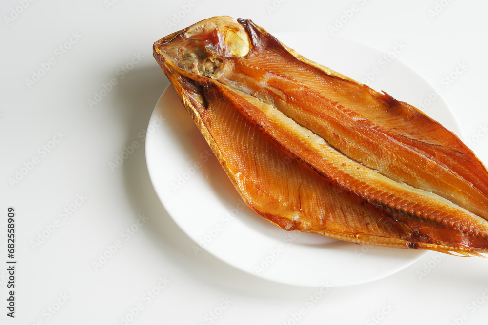 Prepared smoked Baikal omul in a white plate. Innards of gutted smoked ...