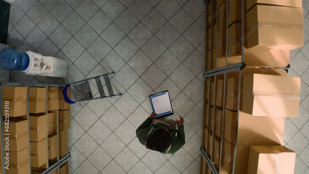 Top down view of african american inspector examining cardboard box ...