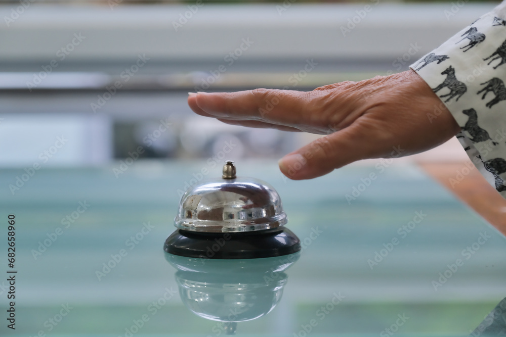 Poster Close-up fore finger pressing a service bell on a reception desk ...