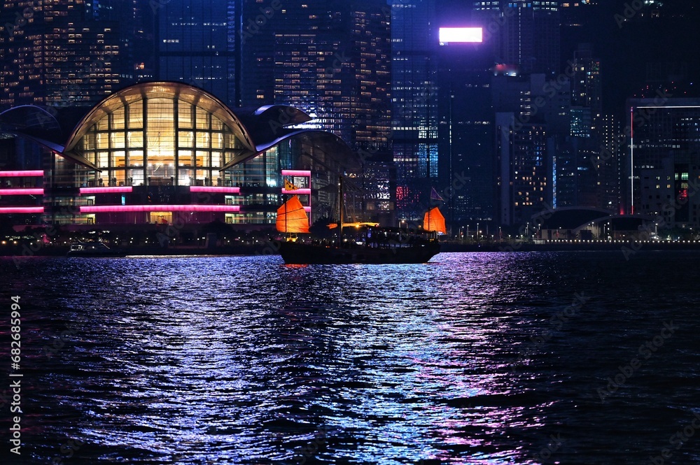 Traditional Hong-Kong junk board crossing the harbor at night. On mast flag name of a pirate ...