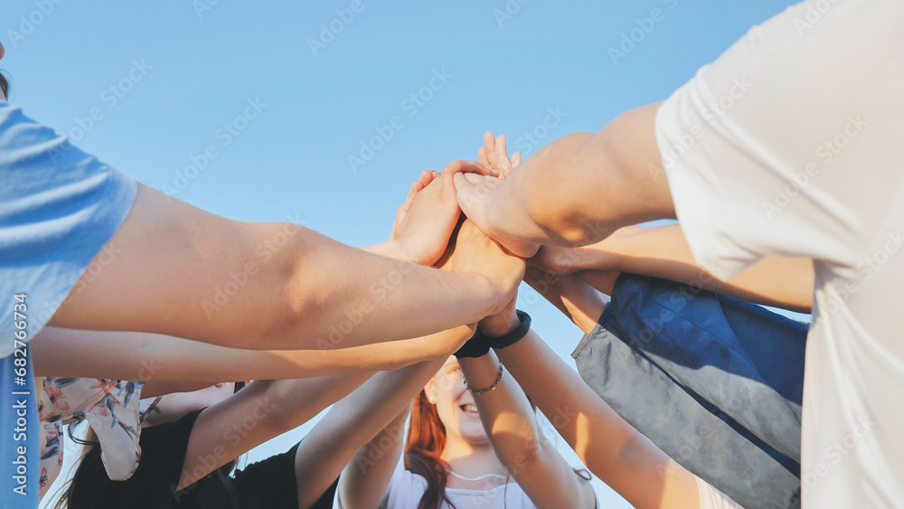 Friends putting their hands together in a sign of unity and teamwork ...