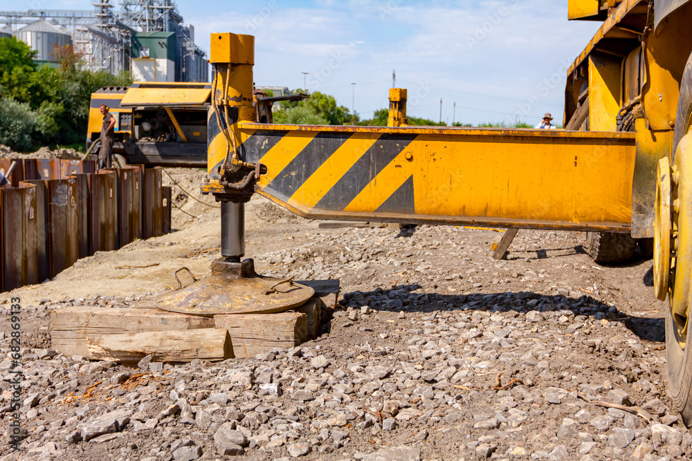 Hydraulic crane foot is supported by metal plate for safety, lateral ...