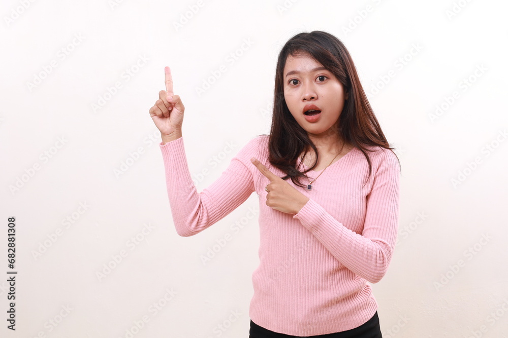 Wow shocked young asian girl pointing above while looking at the camera ...