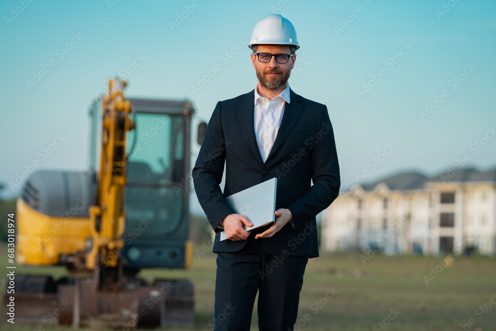 Construction owner near excavator. Confident construction owner in ...