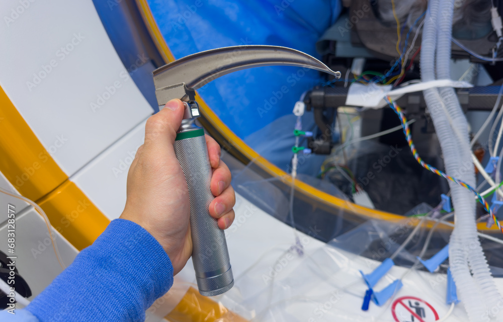 medical professional using airway equipment, mask, laryngoscope, and ...