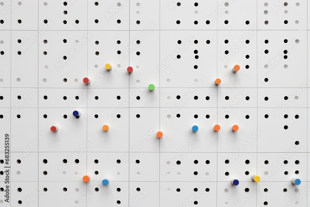 Simetrical rows and columns of holes on a white pegboard Stock Photo ...