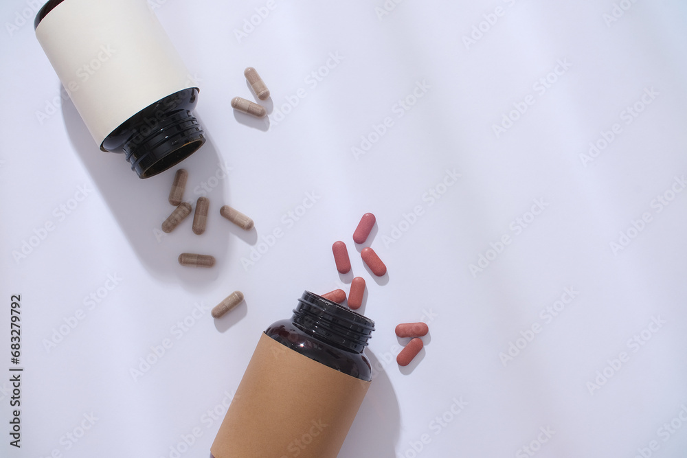 Top view of pills poured onto a white table from two unlabeled pill ...