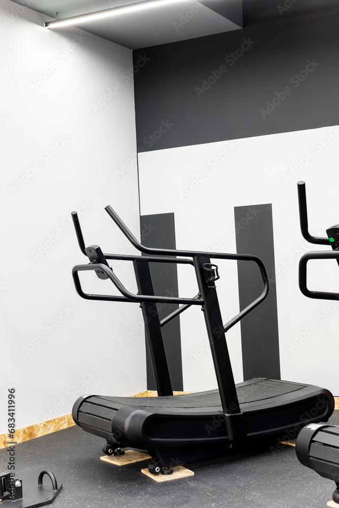 Vertical photo of a curved treadmill inside a gym. Curvy sports tape ...