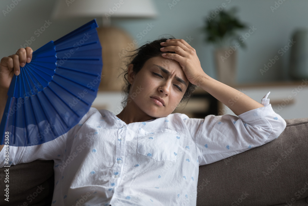 Young diseased Indian woman suffers from high temperature, heat at home ...