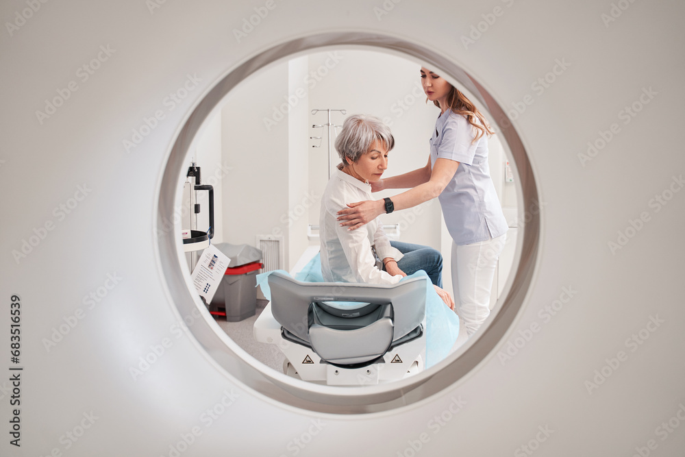 Hospital radiographer with female patient operating CT scanner Stock ...