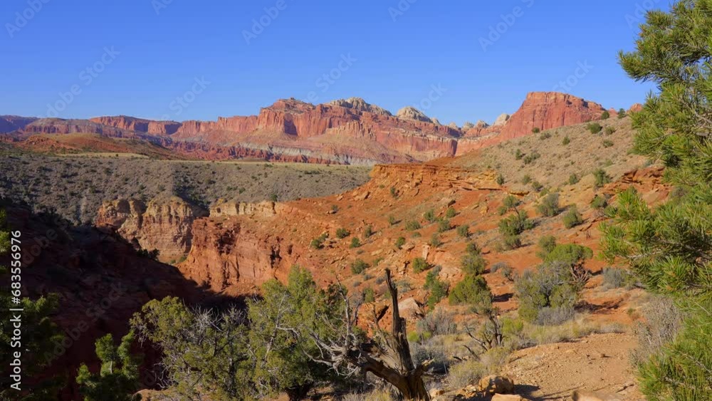 Establishing shot of mountain trail with red rocks background in ...