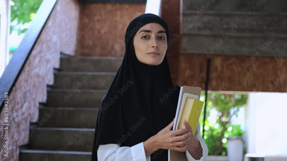 Muslim female student in hijab with books in hands at university or ...