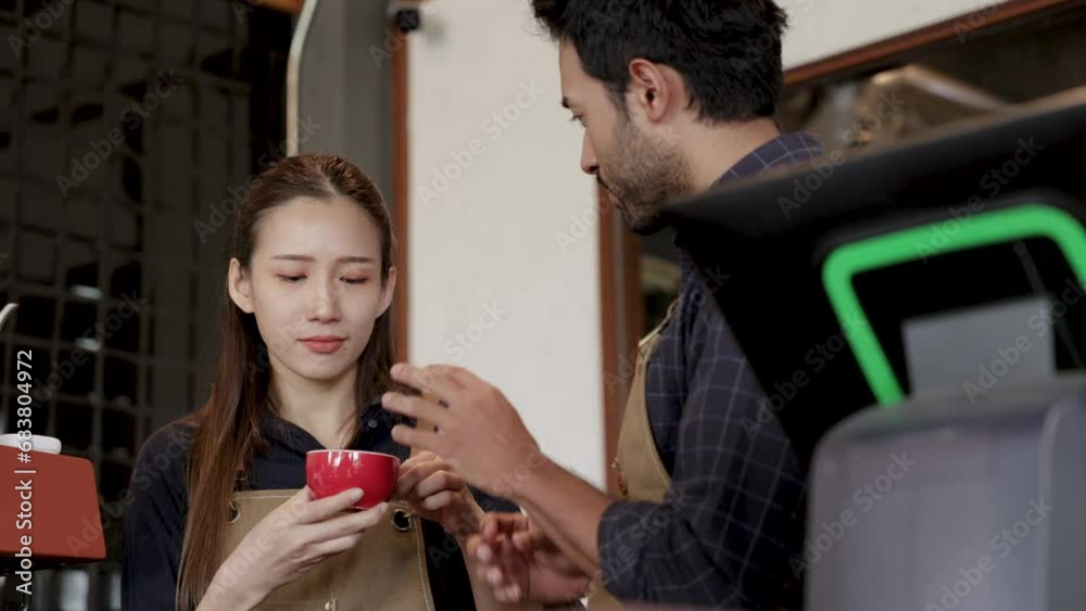 Two cheerful baristas running coffee shop using modern technology POS ...