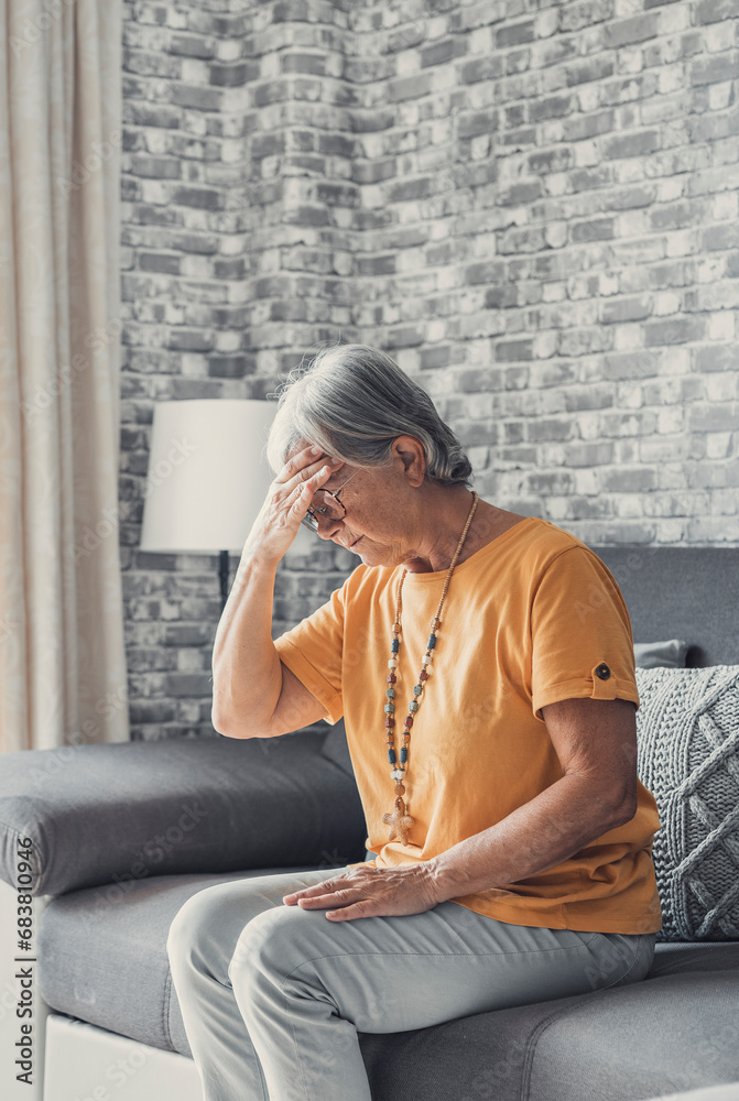 Sad depressed middle aged mature woman sitting alone at home touching ...