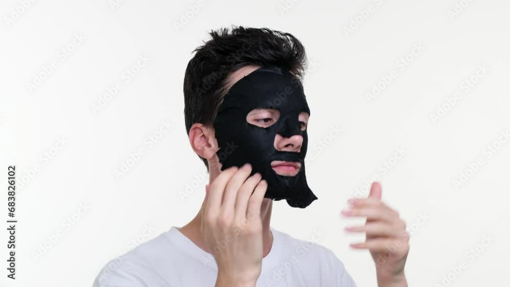 Positive and cheerful man wears a black facial mask, eyes twinkling ...