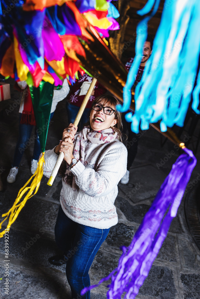 Latin family breaking a pinata at traditional mexican posada ...