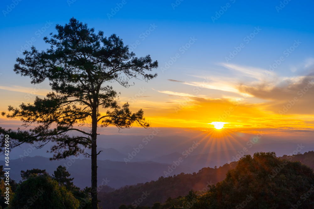 Sun rays shine through trees on a hill mountain in Huai Nam Dang ...