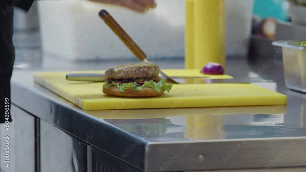 Placing a cooked hamburger patty on the buns at the american fast food ...