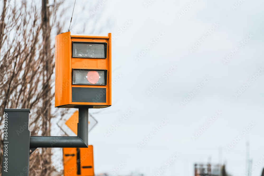 A radar-equipped speed camera monitors the traffic on a road, flashing ...