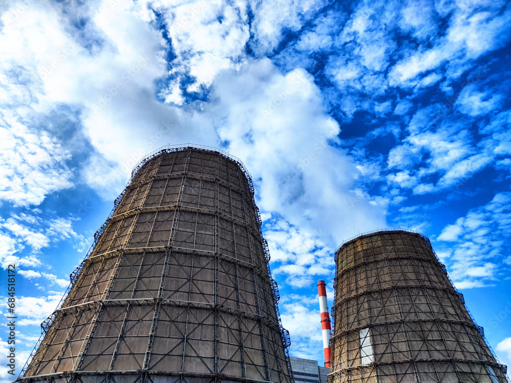 Big tower of CHPP close-up. White steam from wide pipe of CHP on blue ...