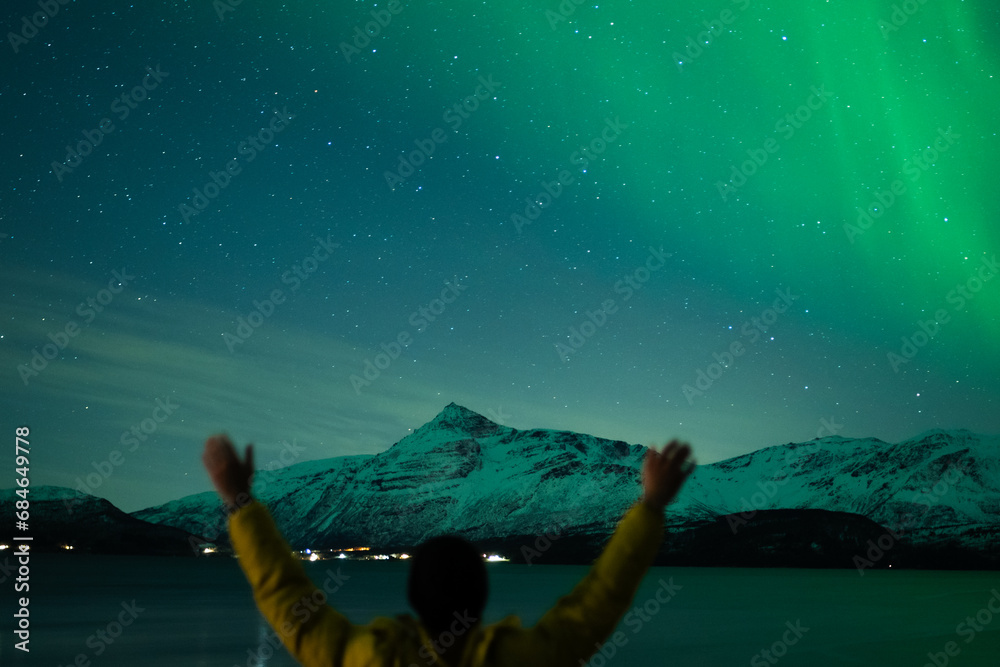 Person reaching up to green Northern Lights Dancing in Arctic skies ...